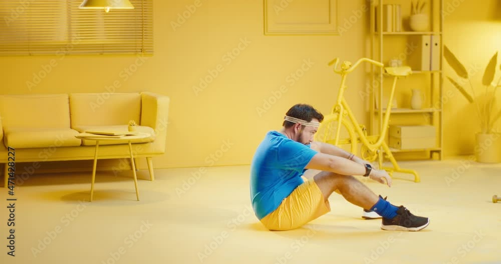 Exhausted overweight bearded young man doing sit ups and taking a break ...