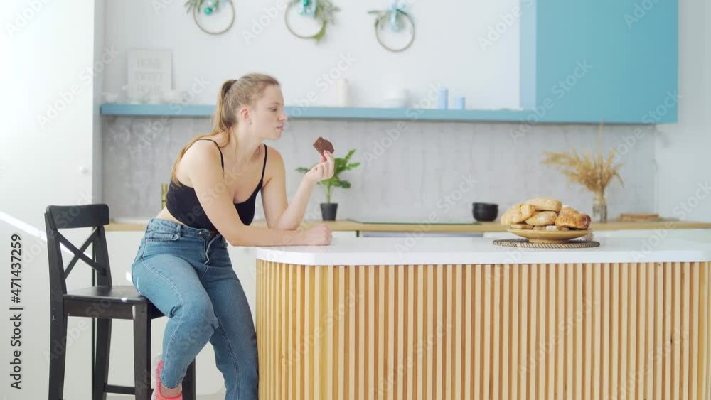 Sad bbw girl eating junk food sitting at home in the kitchen. Young fat ...