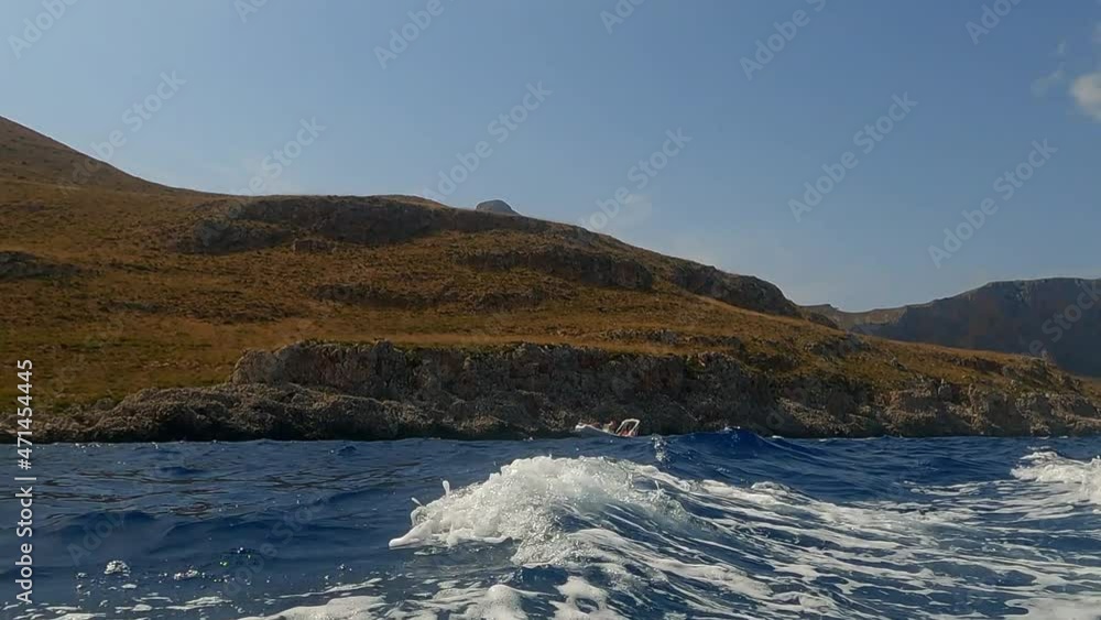 Low-angle sea-level view of dinghy motorboat navigating on sea water as ...