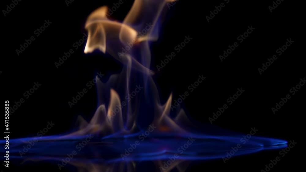 Falling match causes flames to ignite against black studio background ...