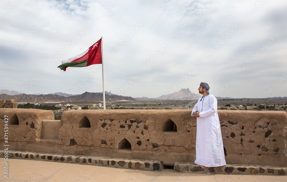 Photo & Art Print omani man in traditional outfit looking at the ...