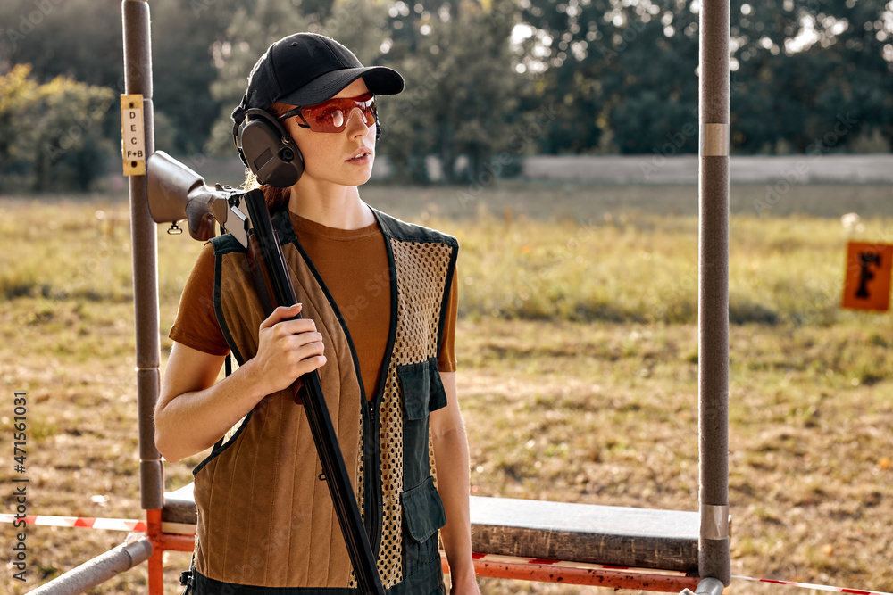 confident caucasian female trains to shoot with double-barreled hunting ...