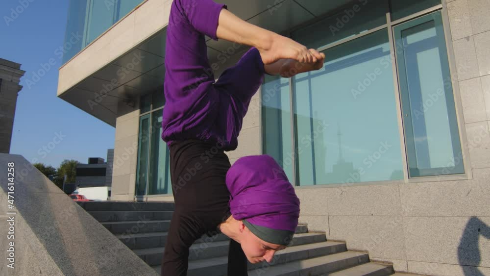 Pincha Mayurasana balance outdoors. Moving footage muslim girl wearing ...