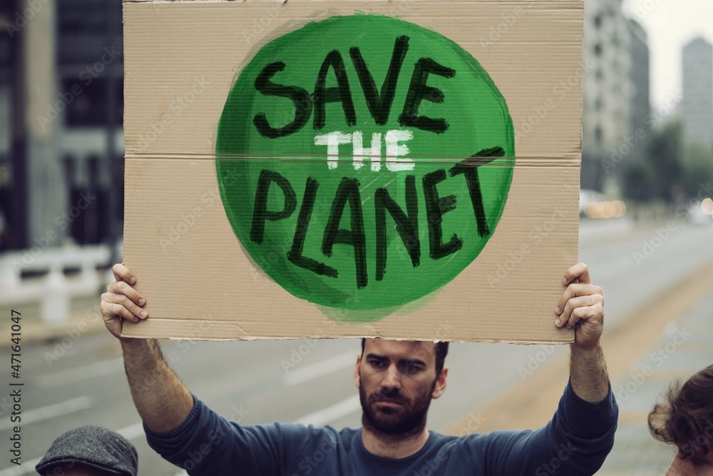 Portrait of an activist marching for rights and showing the sign "Save ...