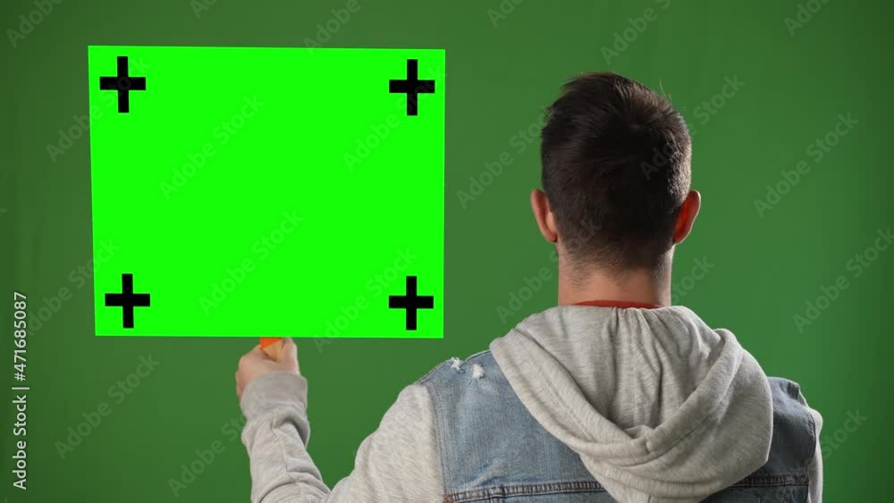 Back of man holding a green screen chroma key blank sign on green ...