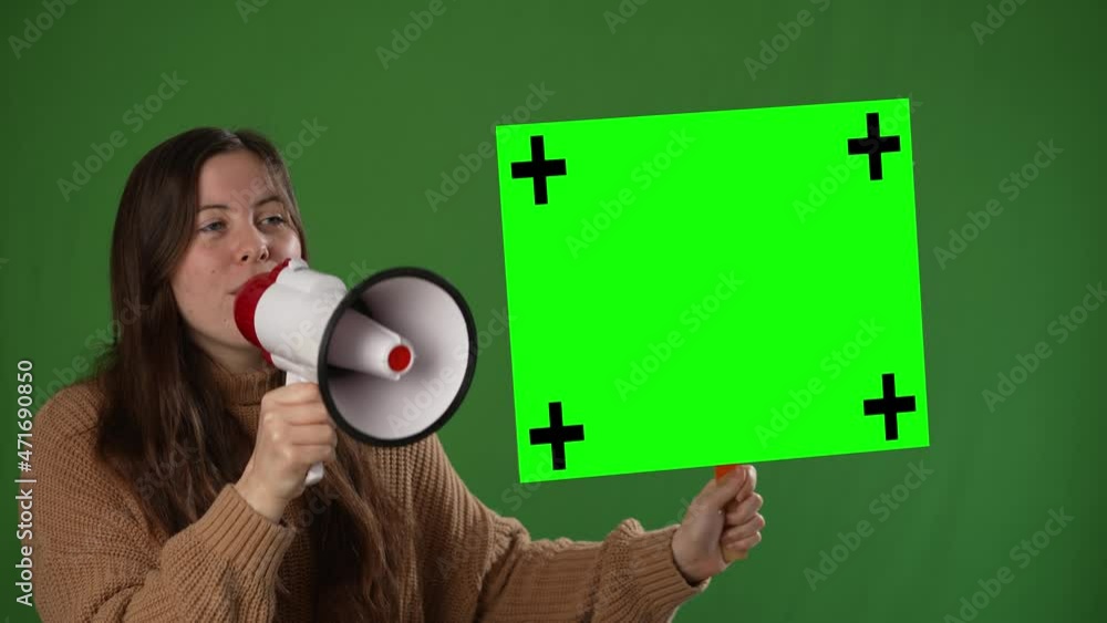 A woman holds a green screen chroma key blank sign and yells into ...