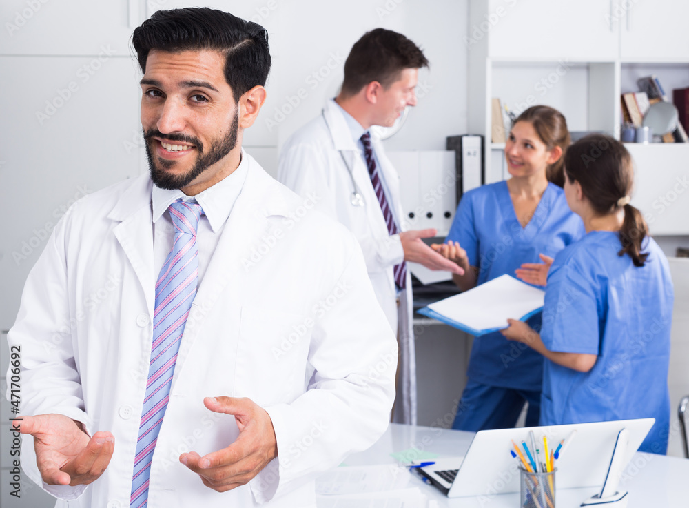 Bearded doctor making welcome gesture, politely inviting patient in ...