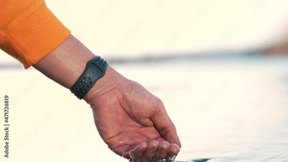 Man hand is touching water. Clean ocean. Fingers touch water in lake ...