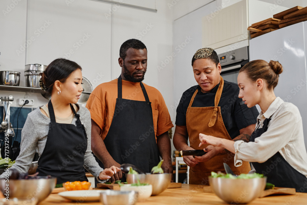Waist up portrait of diverse group of people listening to chef in ...