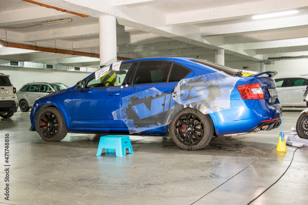 Installation of black vinyl gloss stickers on the side of a blue sports ...