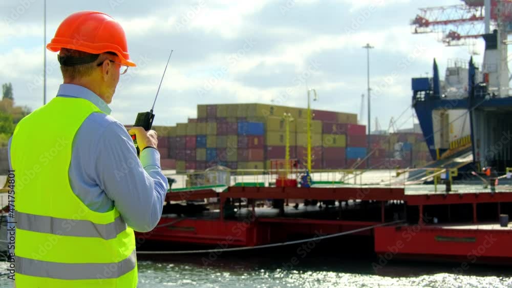 Ship cargo loading process. Safety manager man in orange helmet with ...