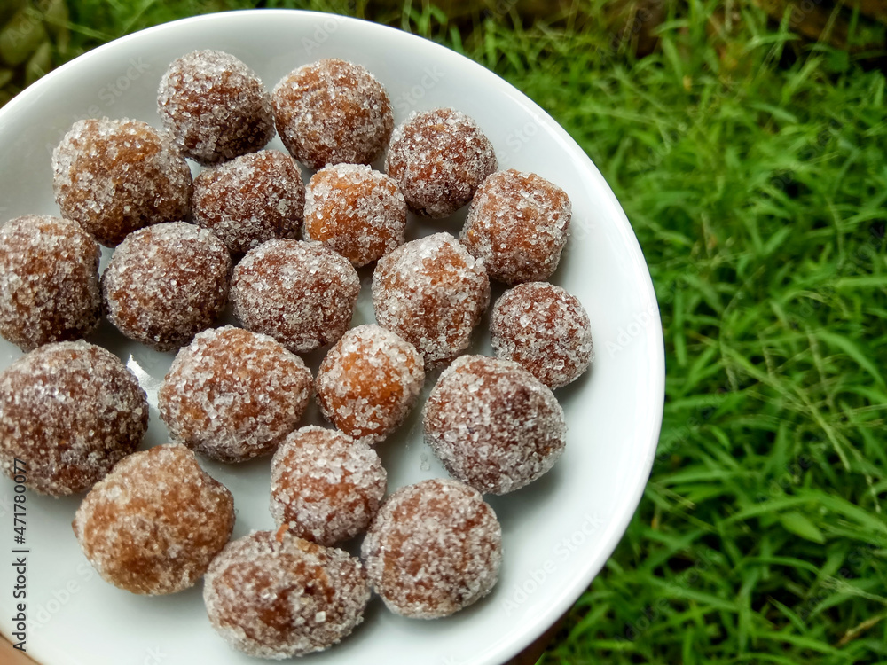 Tamarind candy, placed inside white small plate. Sweet and sour candy ...