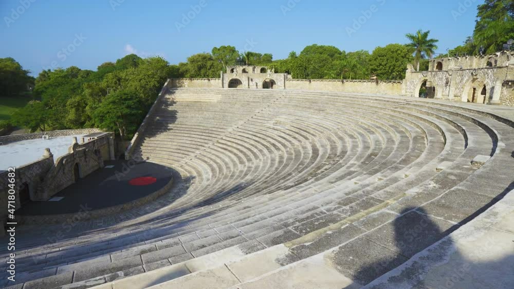 Semicircular rows of seats rise above the stage. The old walls of the ...