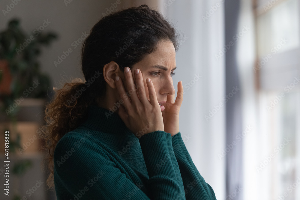 Burning cheeks. Nervous suffering millennial hispanic female standing ...