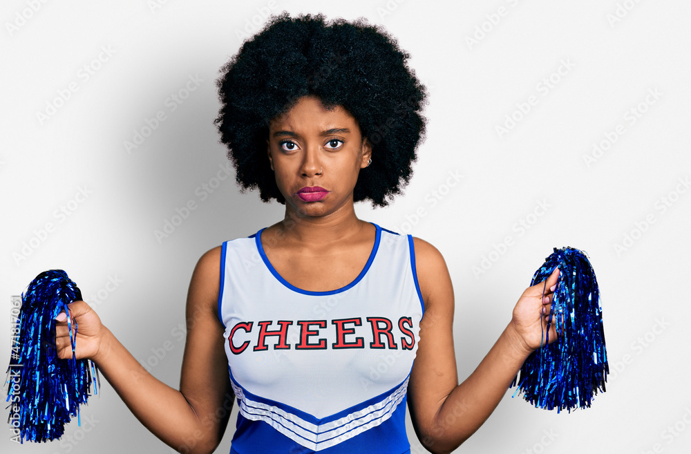 Young african american woman wearing cheerleader uniform using pompom ...