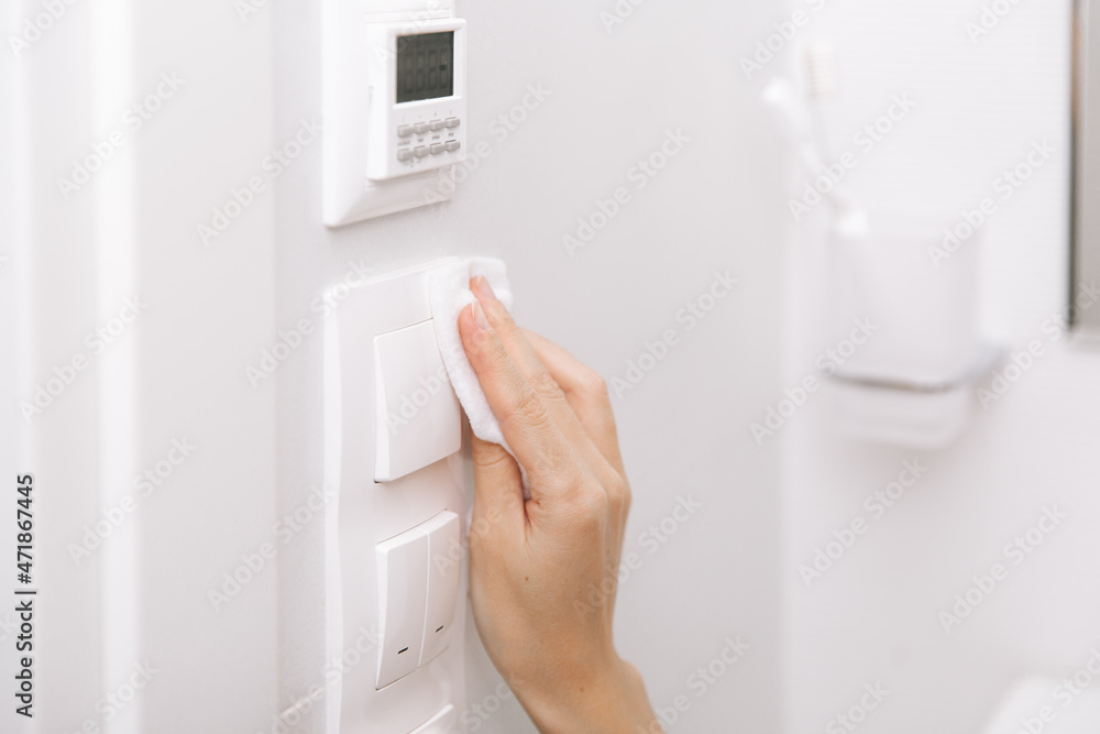Cleaning switches and sockets with a microfiber cloth. Woman hand using ...