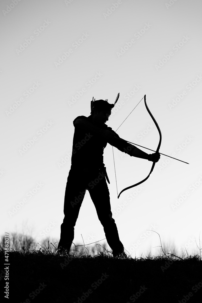 A silhouette of an archer firing an arrow Stock Photo | Adobe Stock