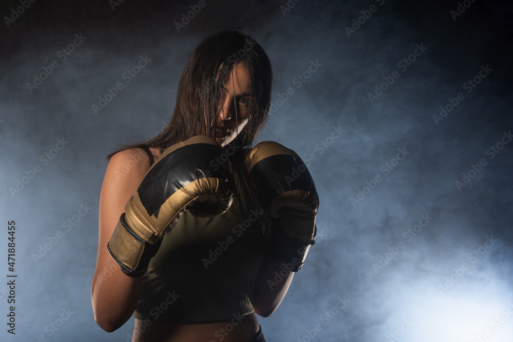 Closeup portrait of a female boxer posing with boxing gloves and ...