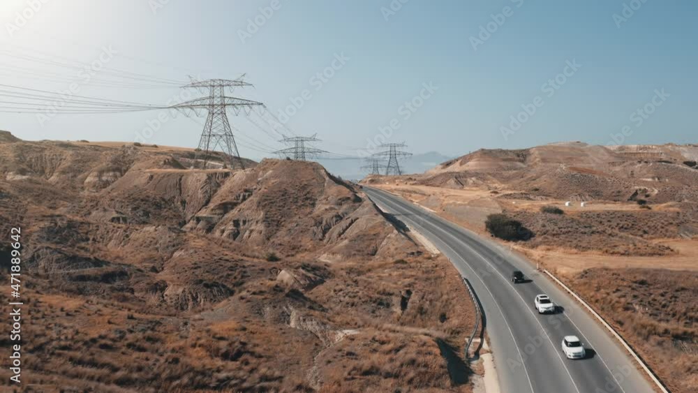 Electric cars driving highway road. High voltage power line in ...