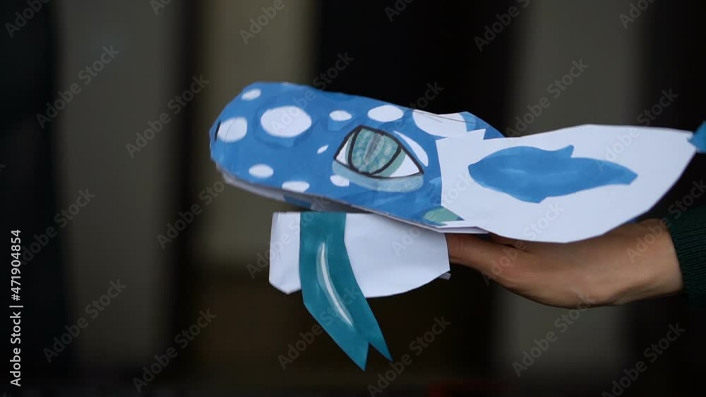 Blue origami dragon with long tongue in child hands, paper dragons ...