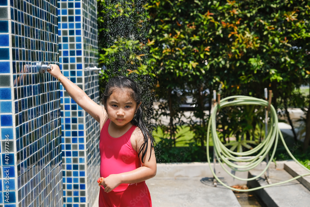 little child girl stand taking a shower after playing in swimming pool ...