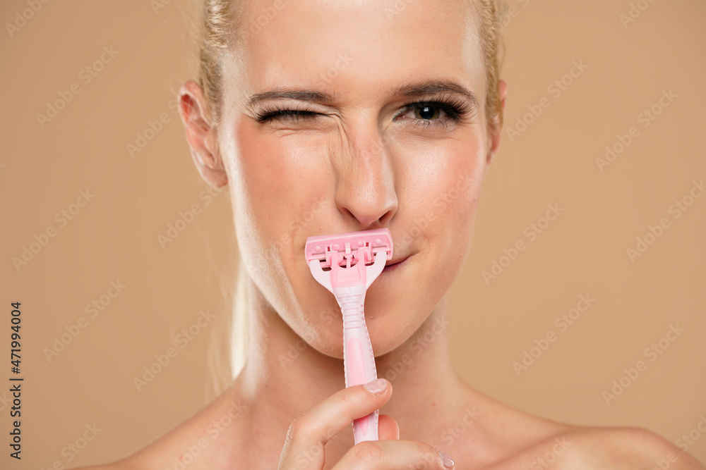 Beautiful young caucasian woman shaving her face by razor Stock Photo ...