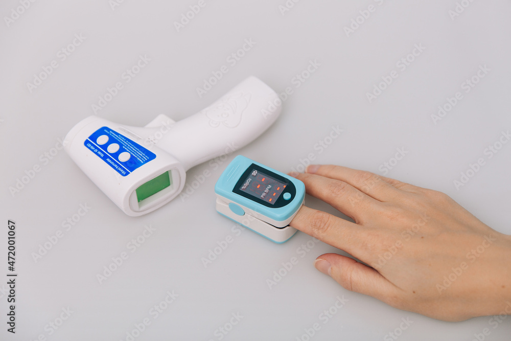 Pulse oximeter and thermometer gun on white background. Infrared ...