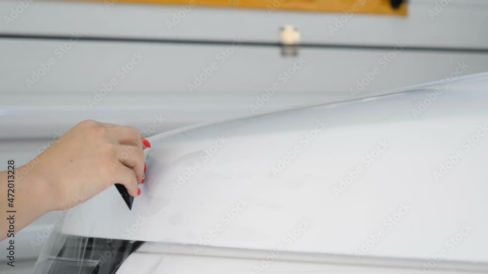 Close up to PPF installation process on a front headlight and hood. PPF ...