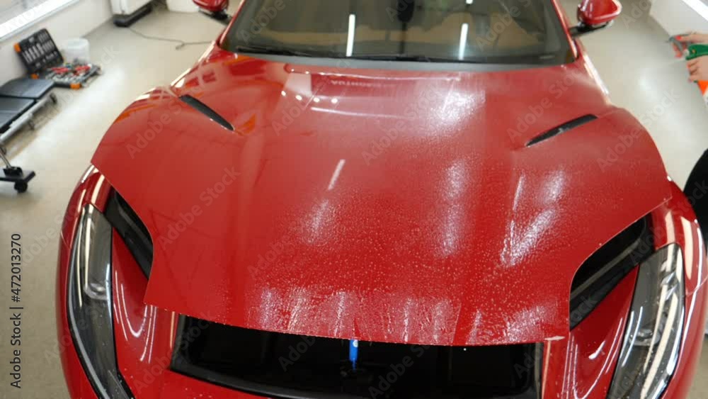 Close up to PPF installation process on a front headlight and hood. PPF ...