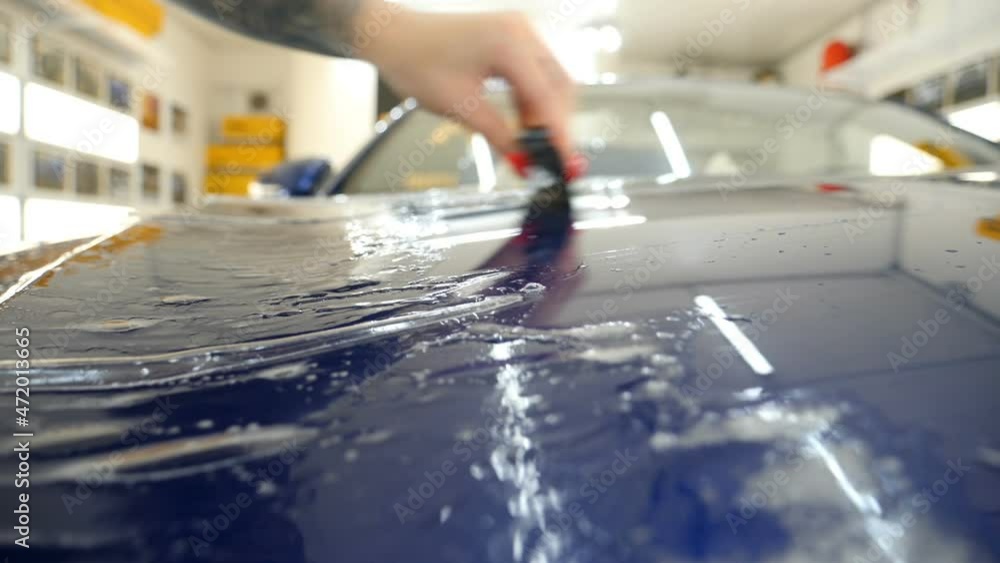 Close up to PPF installation process on a front headlight and hood. PPF ...