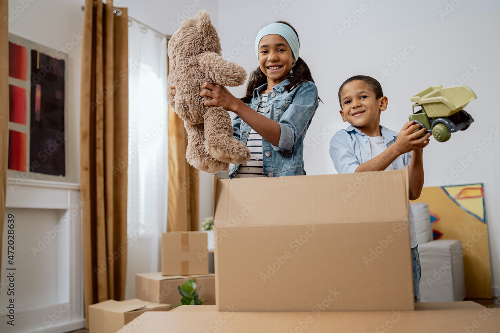 Children are moving with their parents to a new house, unpacking ...