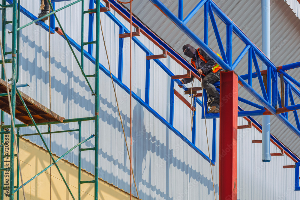 Low angle and side view of construction workers are lifting metal ...
