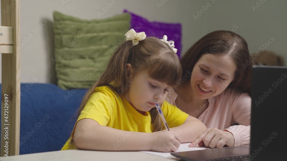 little child writes homework with a pen in a notebook, a kid does ...