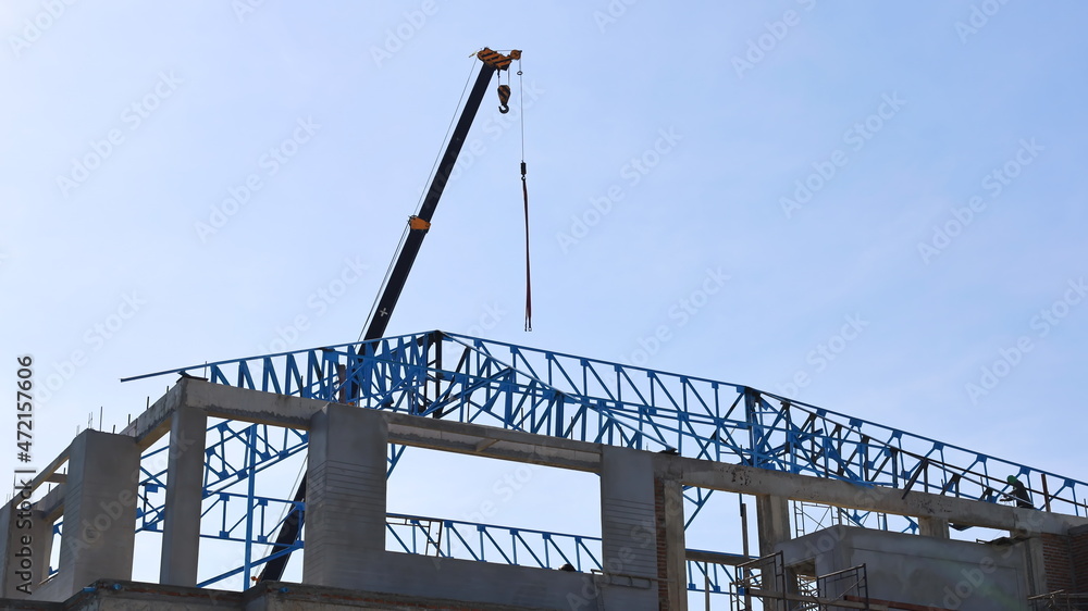 Metal roof structures and cranes. Installation of steel roof trusses ...