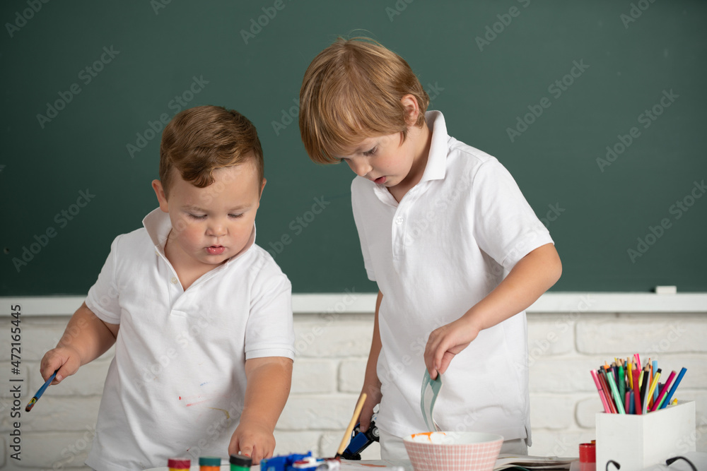 Children boys pupils drawing with coloring pens, painting with early ...