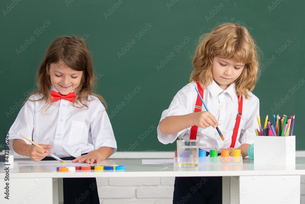 School children drawing a colorful pictures with pencil crayons in ...