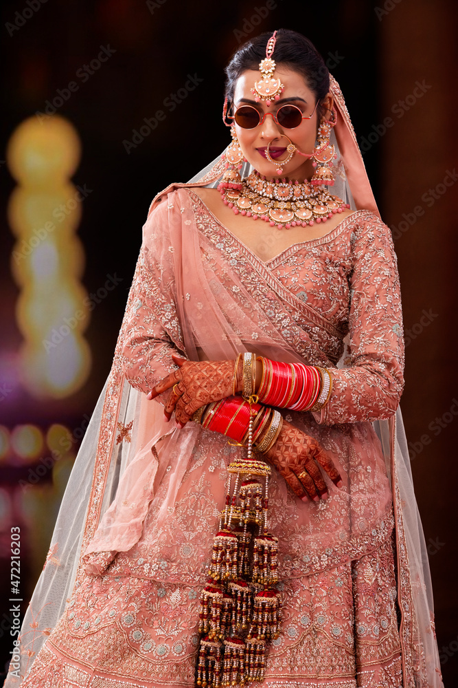 Beautiful Indian bride posing with sunglass during wedding ceremony ...