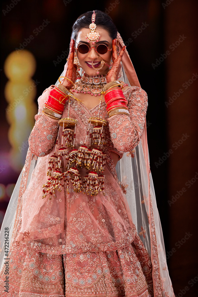 Beautiful Indian bride posing with sunglass during wedding ceremony ...