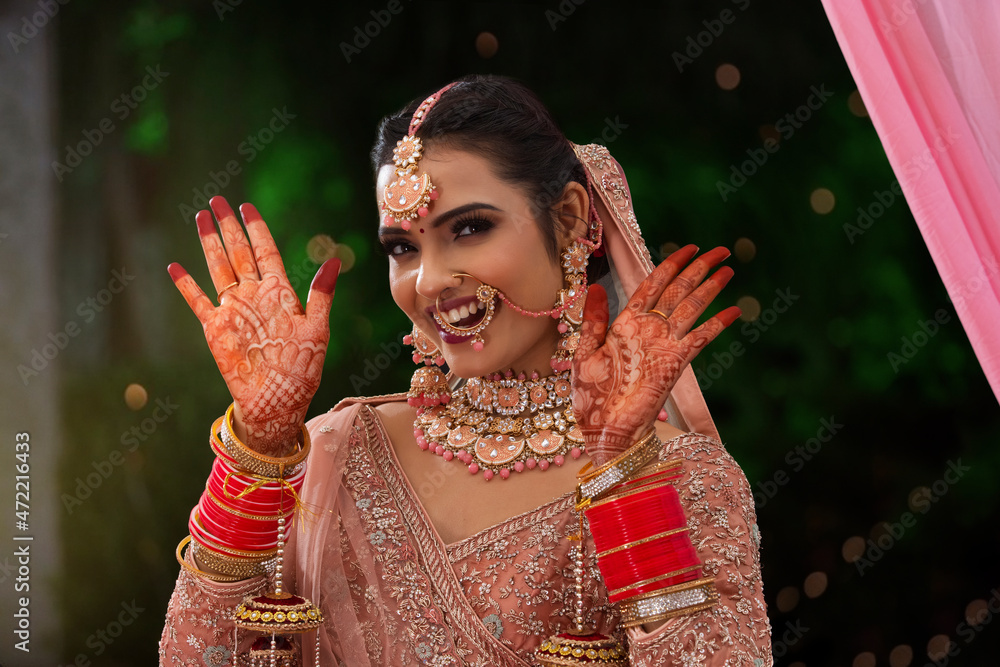 Beautiful Indian woman in traditional wedding dress posing in front of ...