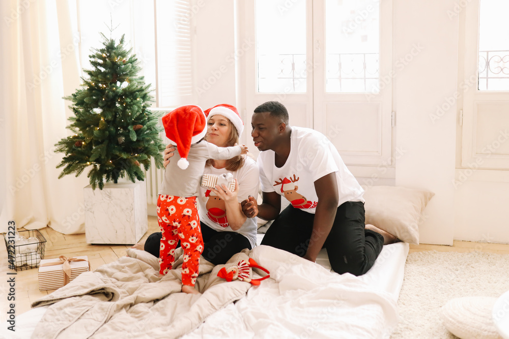 A multiracial mixed race family with a child a little girl in pajamas ...