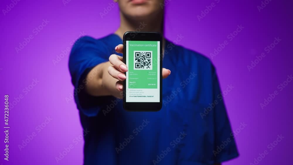 Woman surgeon in medical uniform showing vaccination passport with qr ...
