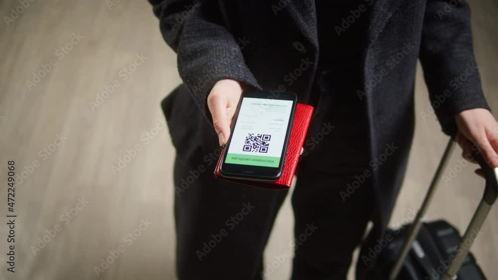 Tourist showing QR code on phone in airport terminal. Vaccination ...