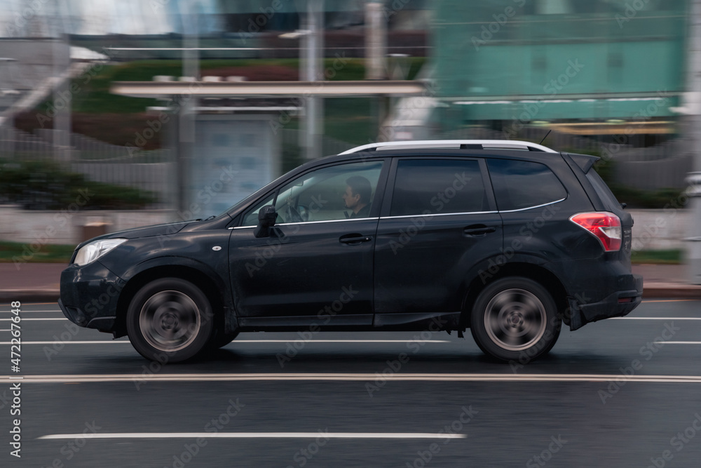 Side view Subaru Forester fourth generation SJ car moving on wet ...
