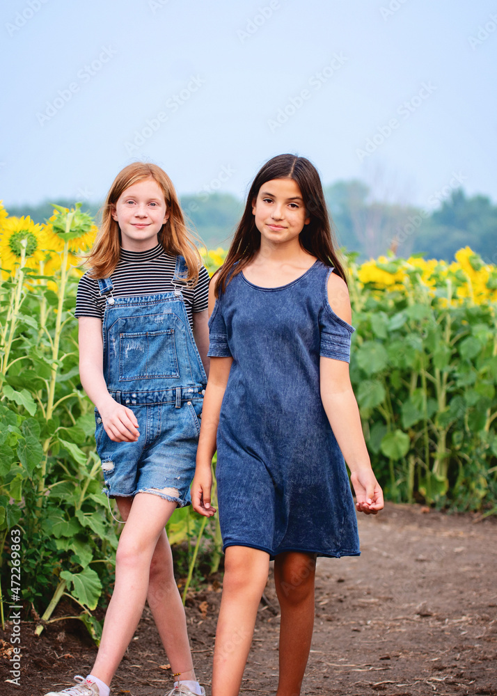Two happy tween girls in a sunflower field. Stock Photo | Adobe Stock