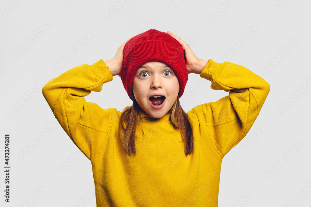 Portrait of shocked stupefied little kid in yellow hoodie looks with ...
