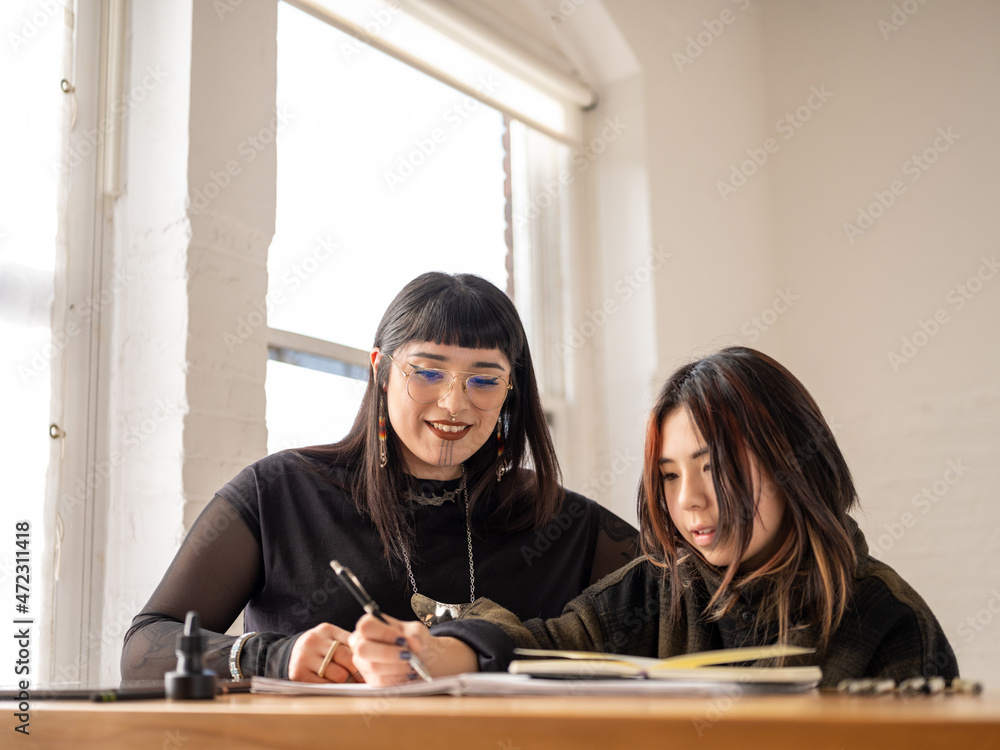 Non binary artist and non-binary student drawing indoors Stock Photo ...