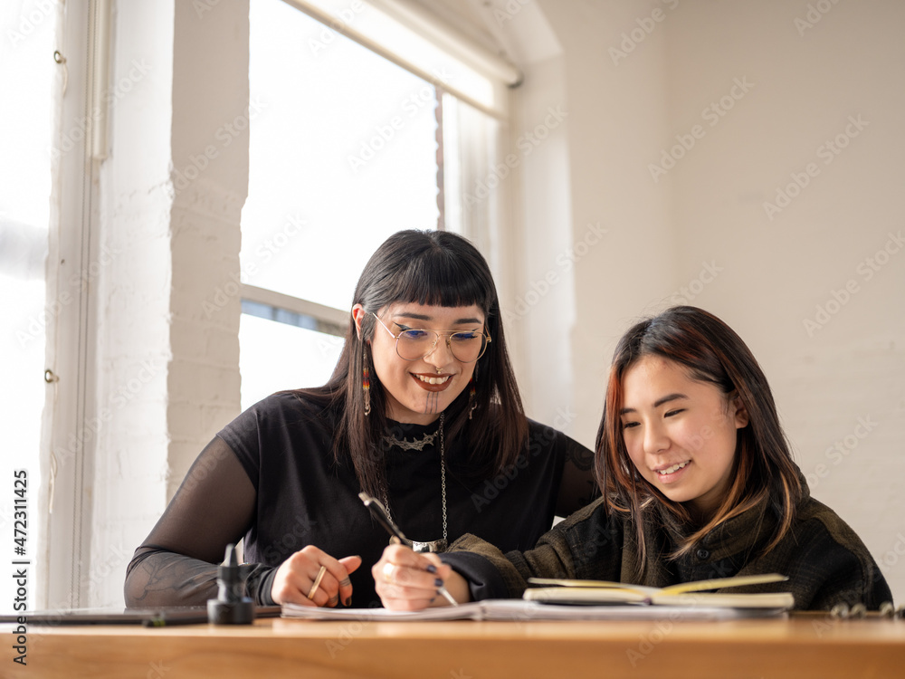 Non binary artist and non-binary student drawing indoors Stock Photo ...