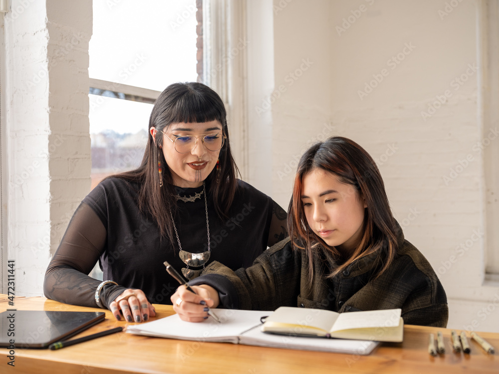 Non binary artist and non-binary student drawing indoors Stock Photo ...