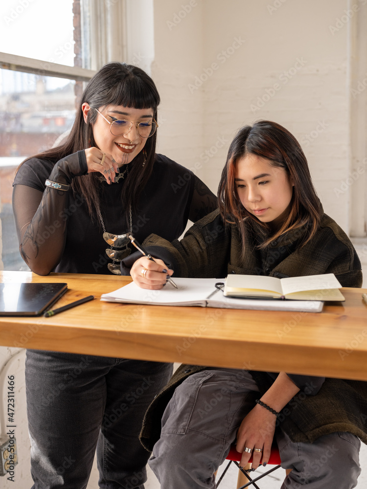 Non binary artist and non-binary student drawing indoors Stock Photo ...