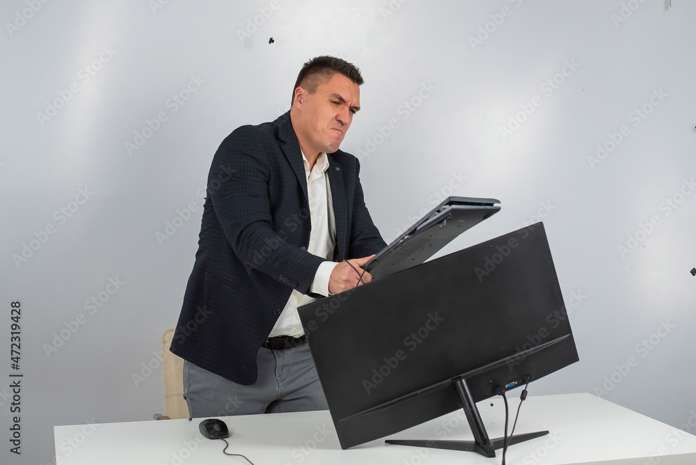 Caucasian man in a suit gets angry and smashes the keyboard on the ...